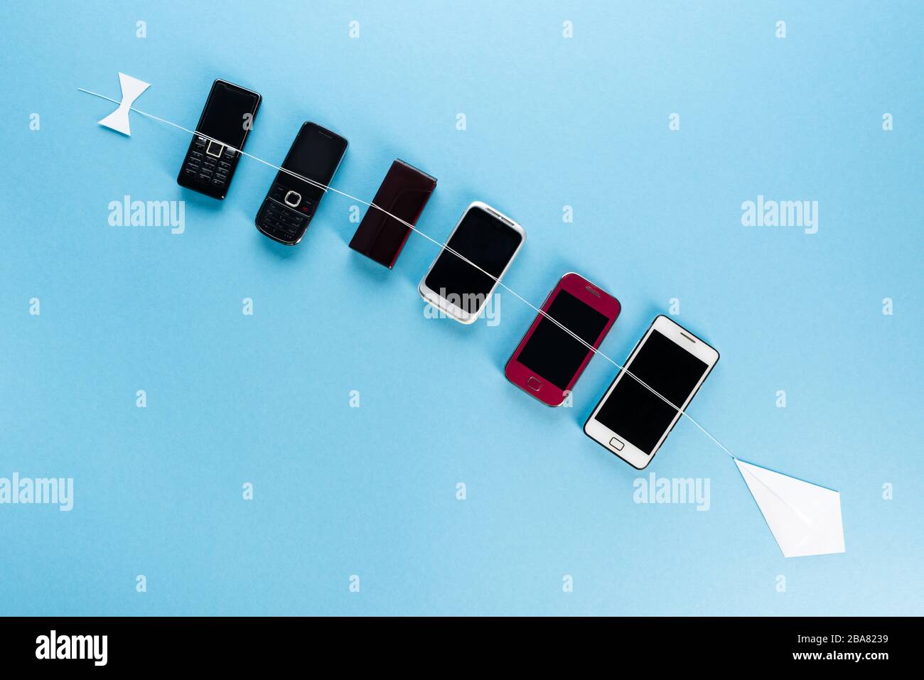 top view of retro mobile phones and modern smartphones on blue ...