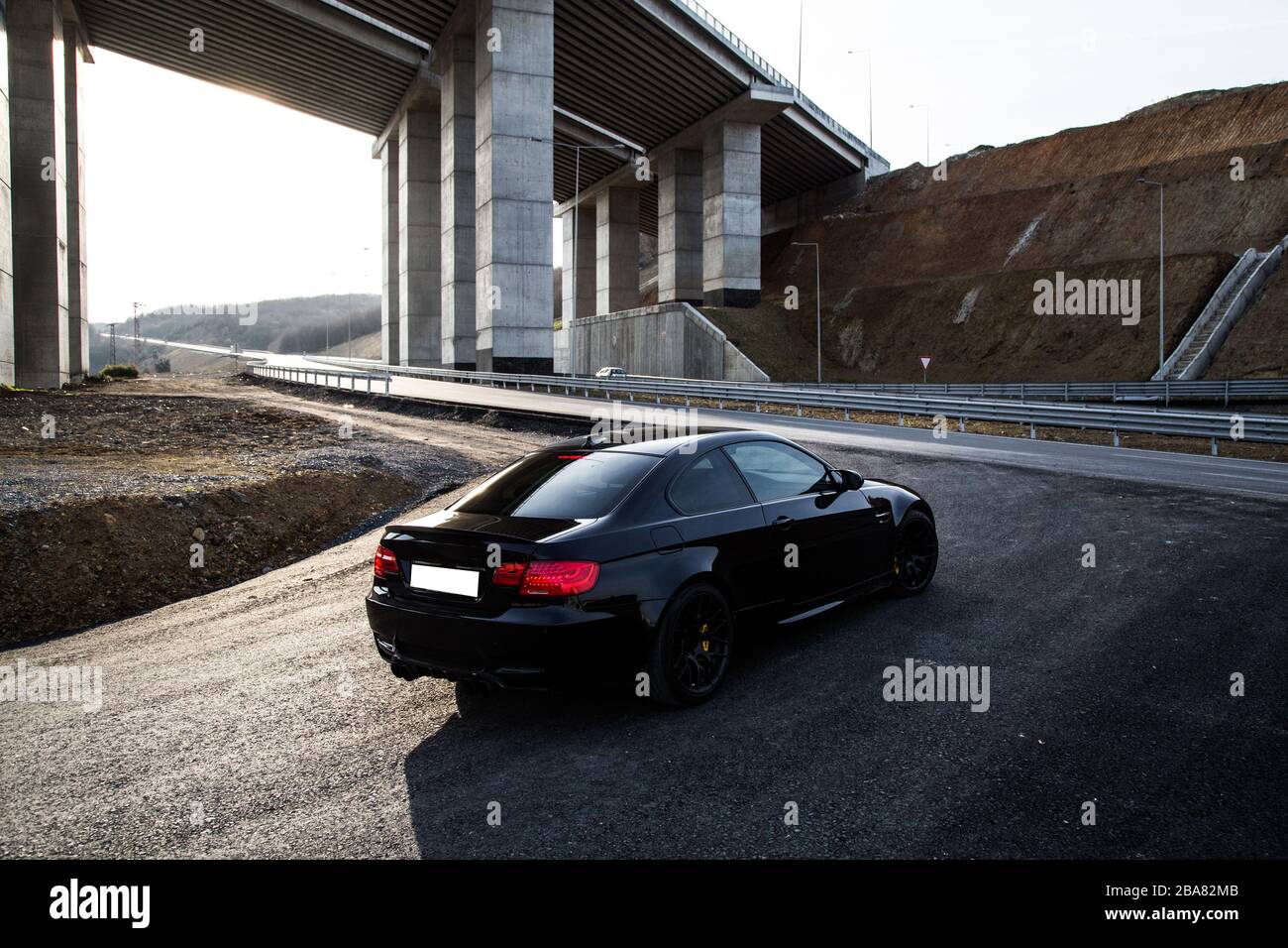 Black sport car on the road under the bridge Stock Photo - Alamy