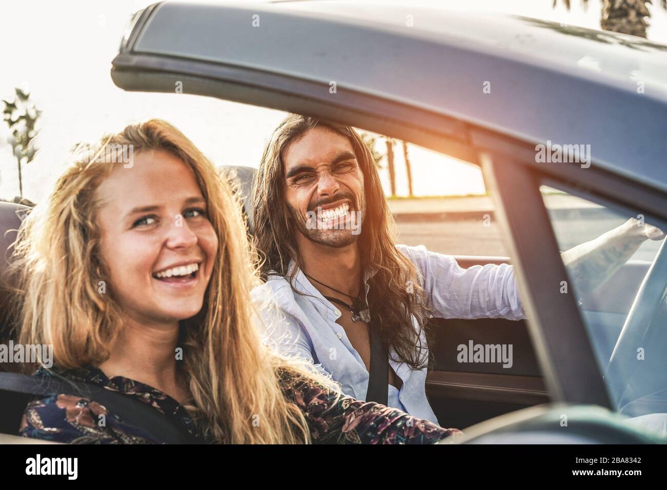 Happy young couple having fun inside convertible sport car - Travel ...