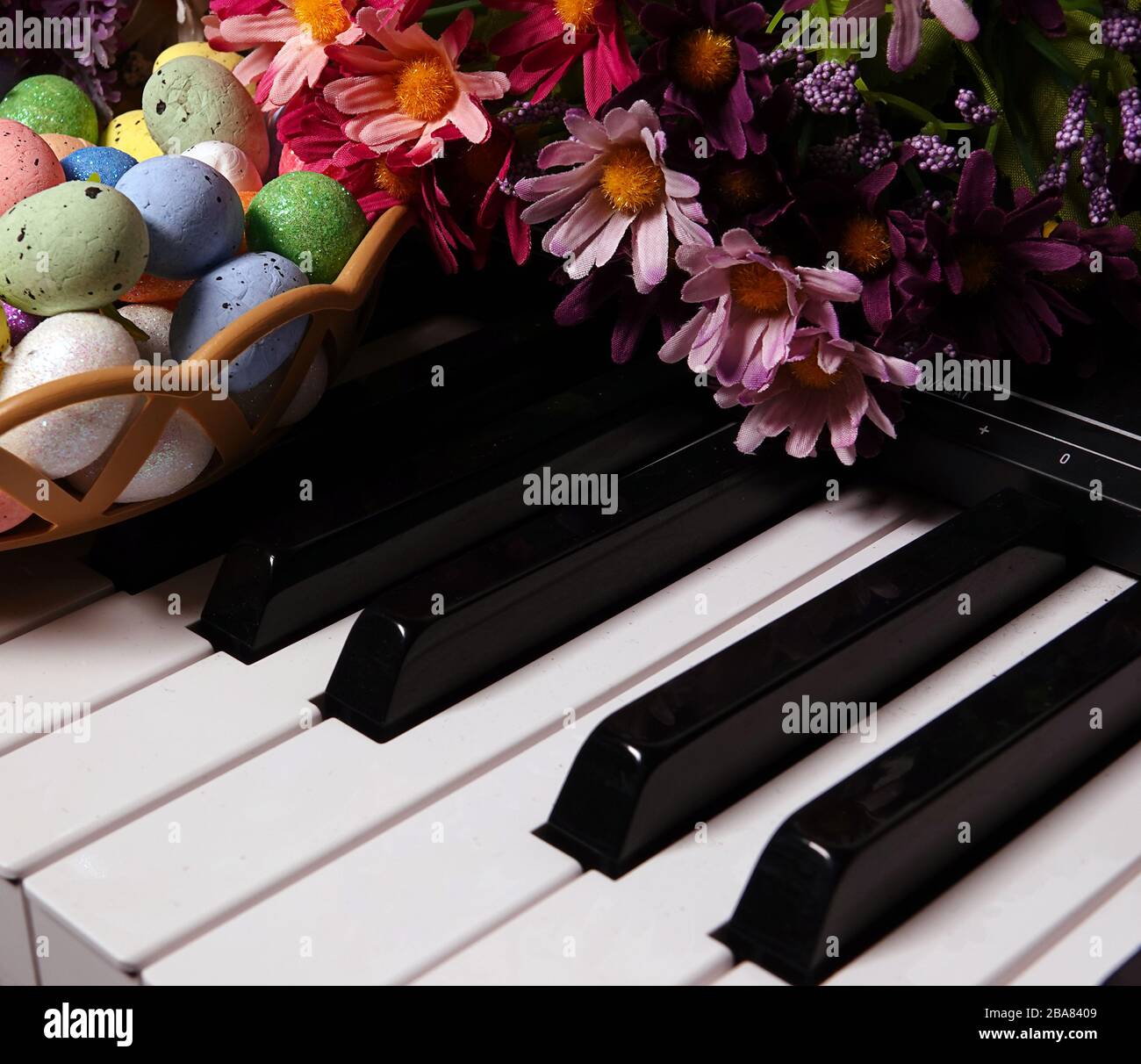 Colorful Paschal Easter Eggs and Piano Keys and Flowers Stock Photo - Alamy