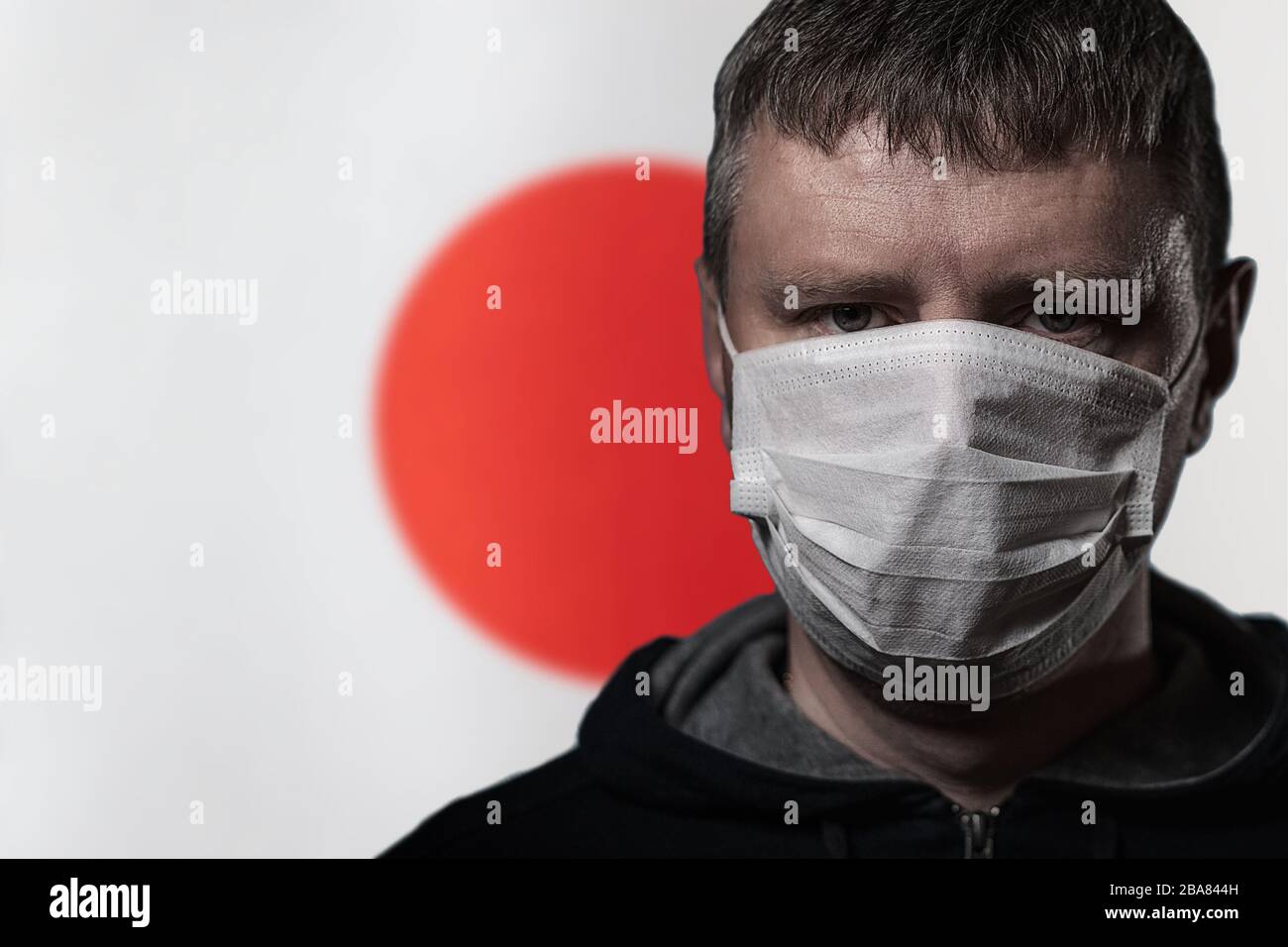 Portrait of a white man in a medical mask on the background of the flag ...