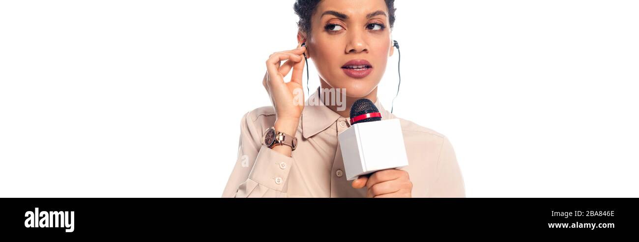 African american journalist with microphone putting headphones in ears ...