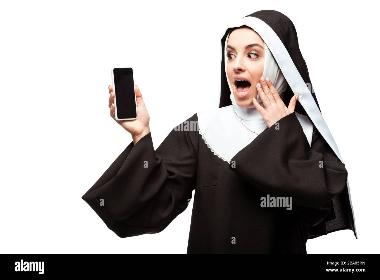 Surprised Nun Presenting Smartphone With Blank Screen Isolated On White