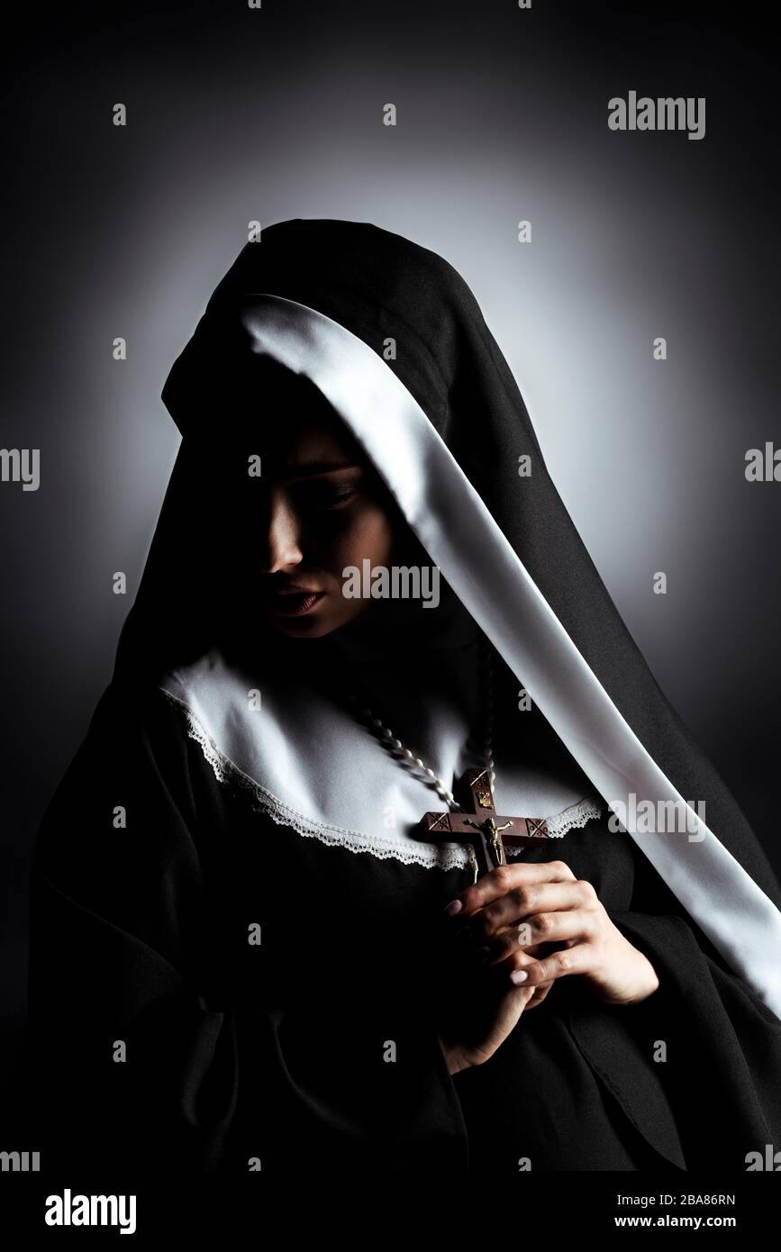 beautiful young sad nun holding cross on grey Stock Photo - Alamy