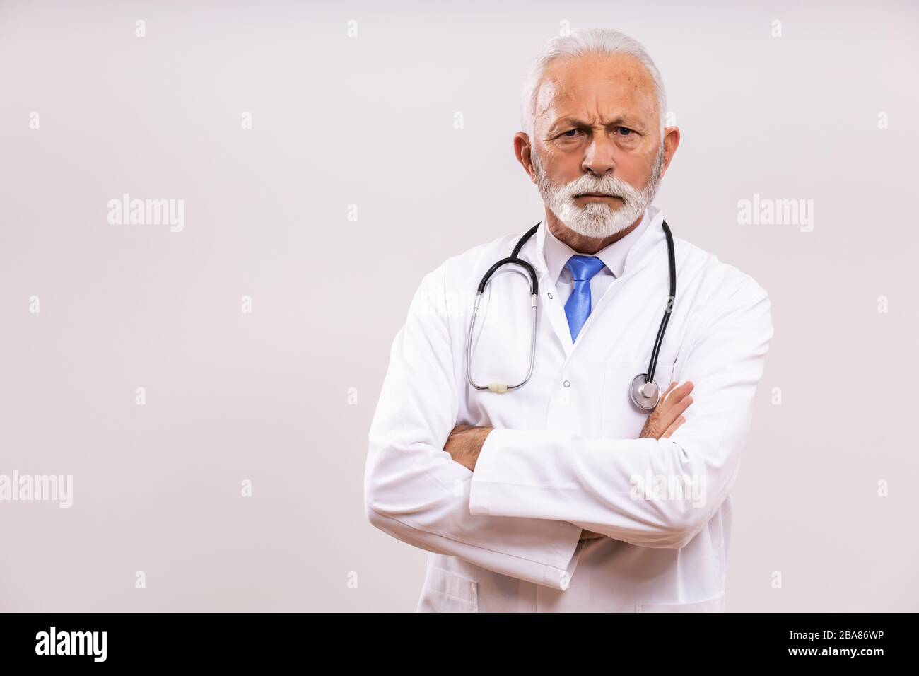 Image of angry senior doctor on gray background Stock Photo - Alamy