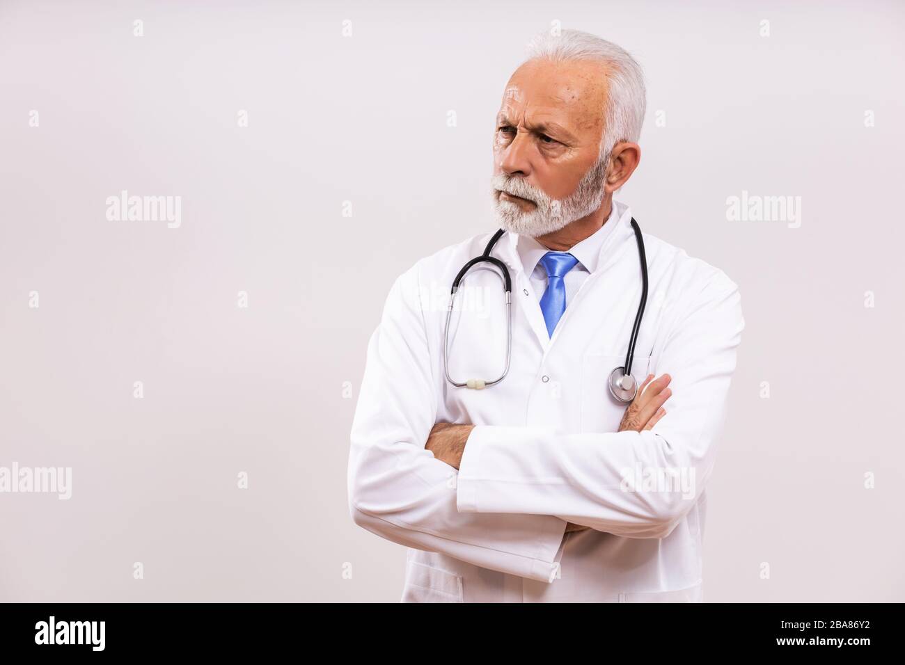 Image of angry senior doctor on gray background Stock Photo - Alamy