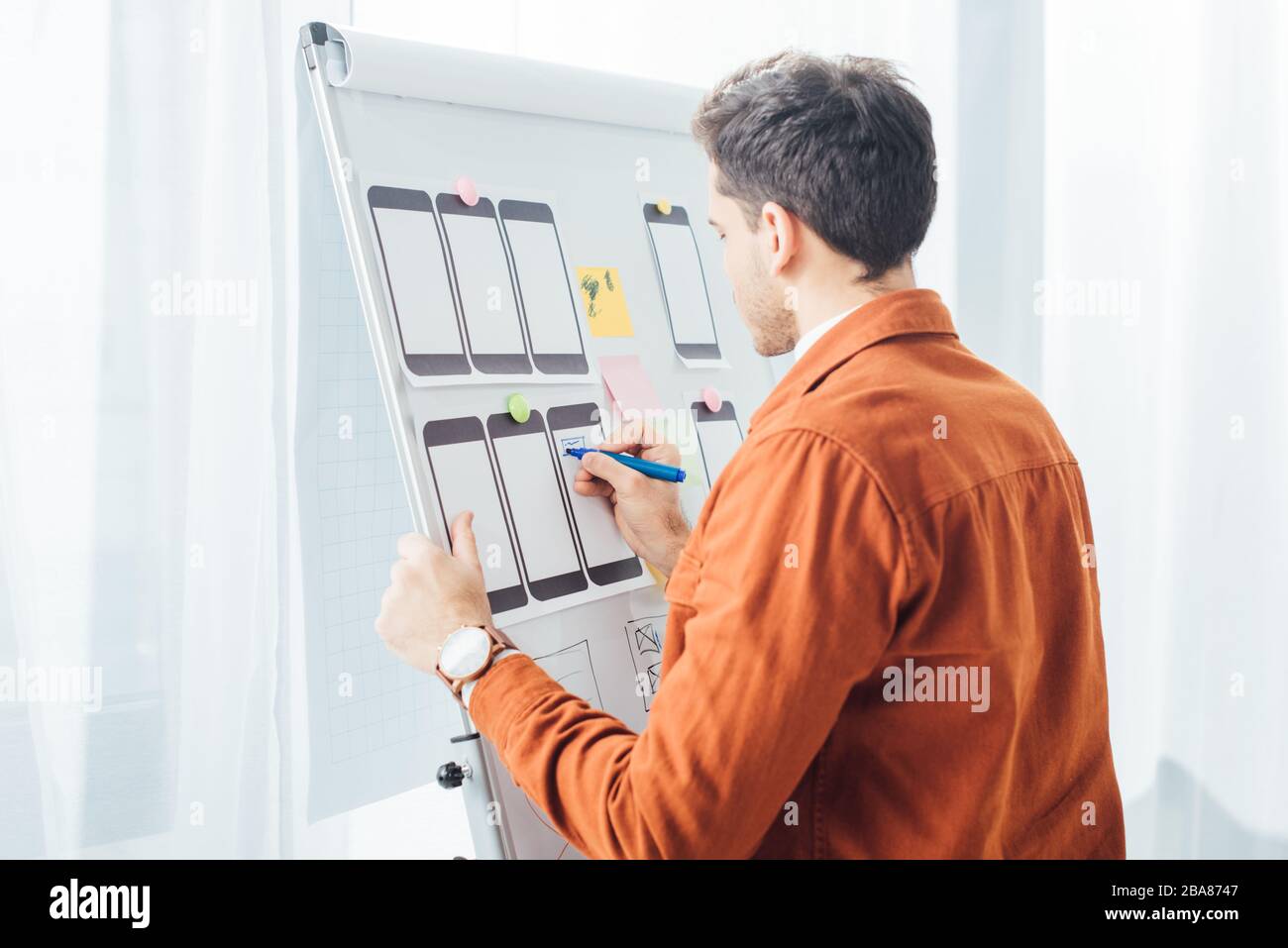 Side view of creative designer using mobile frameworks while developing ...