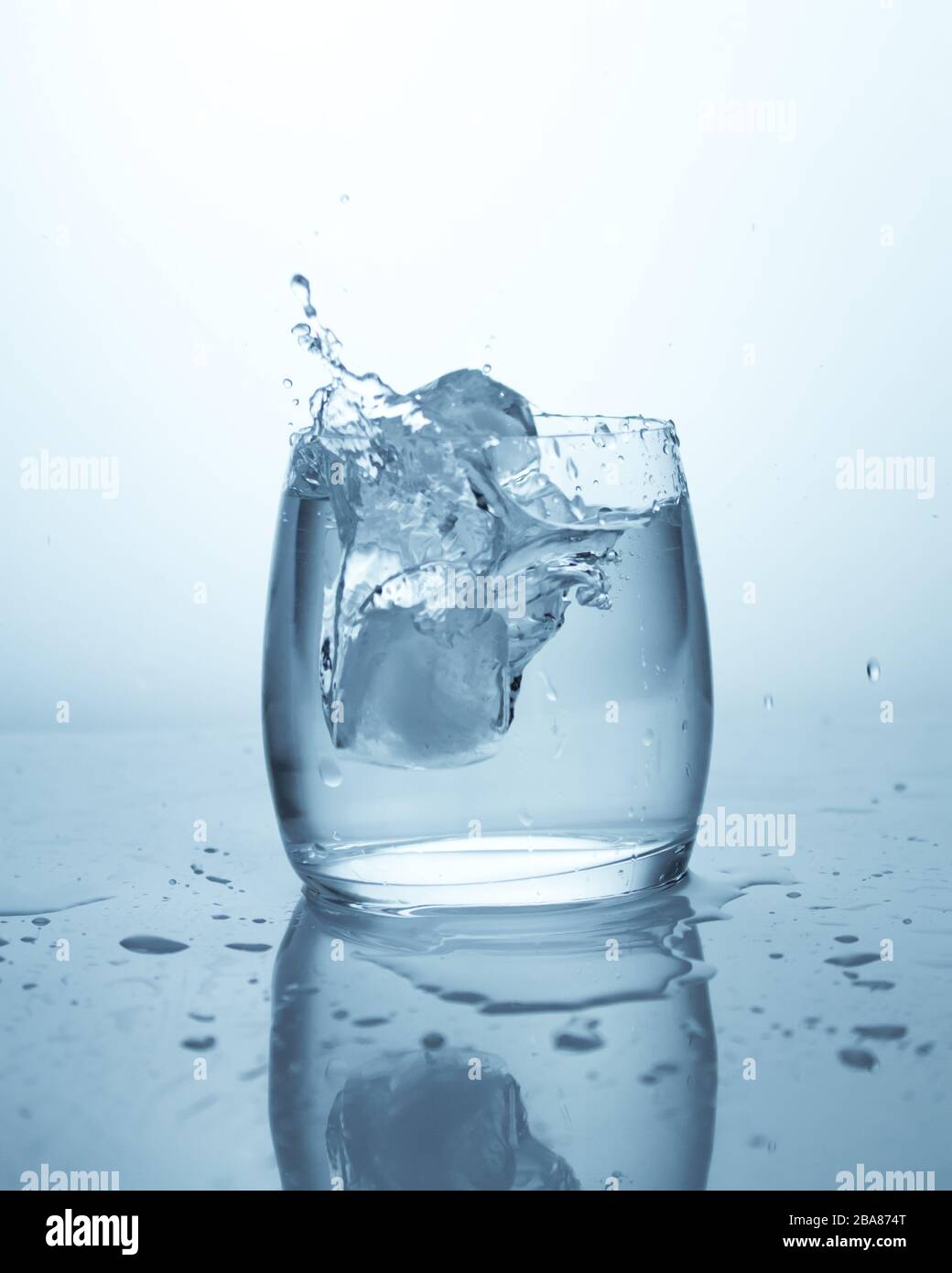 Drop of ice in a glass of water. Pure spring drinking water, drops of ...