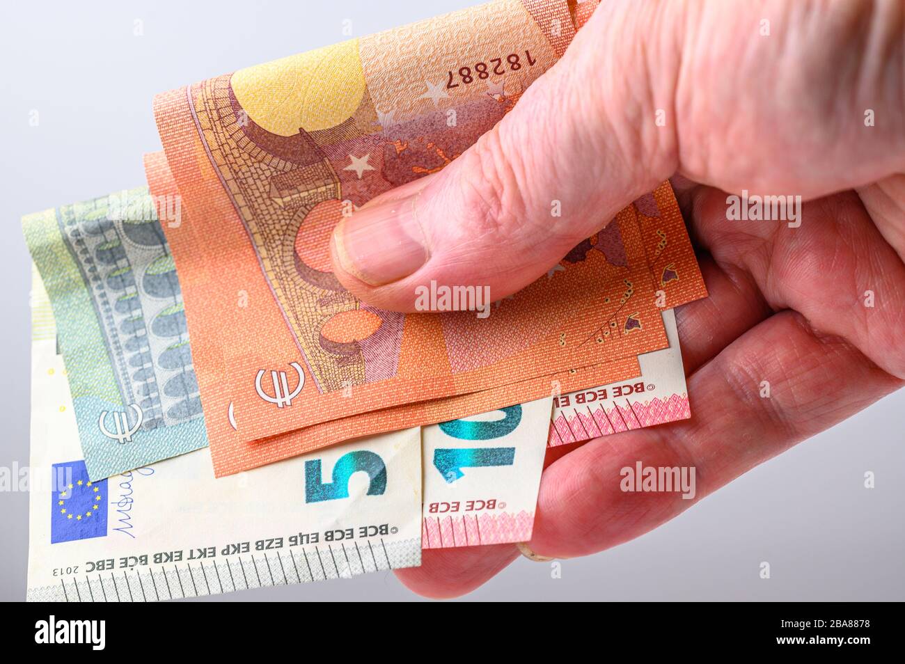 Paying for goods or services with euro notes white background Stock ...