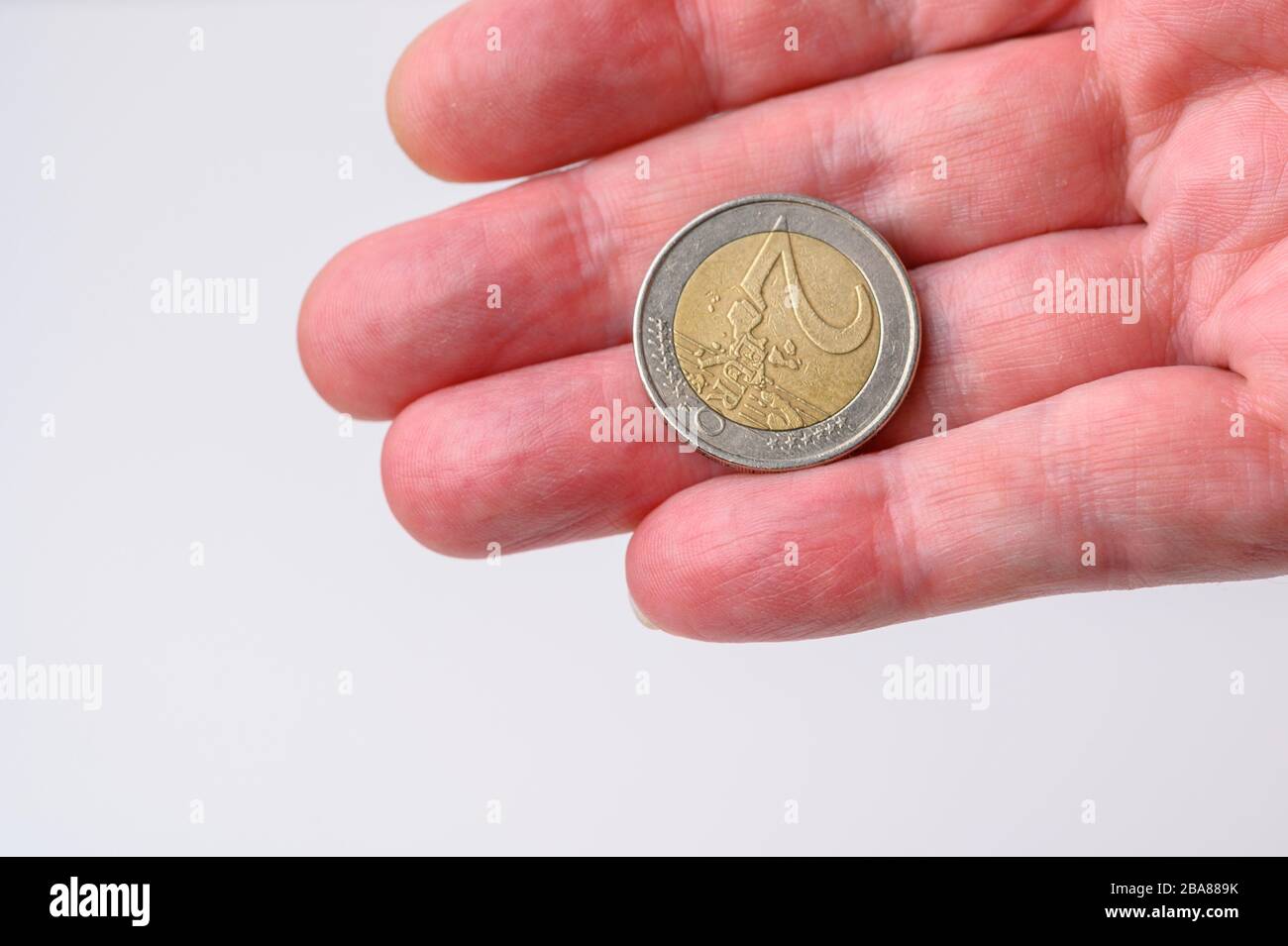 Paying for goods or services with two euro coin white background Stock ...