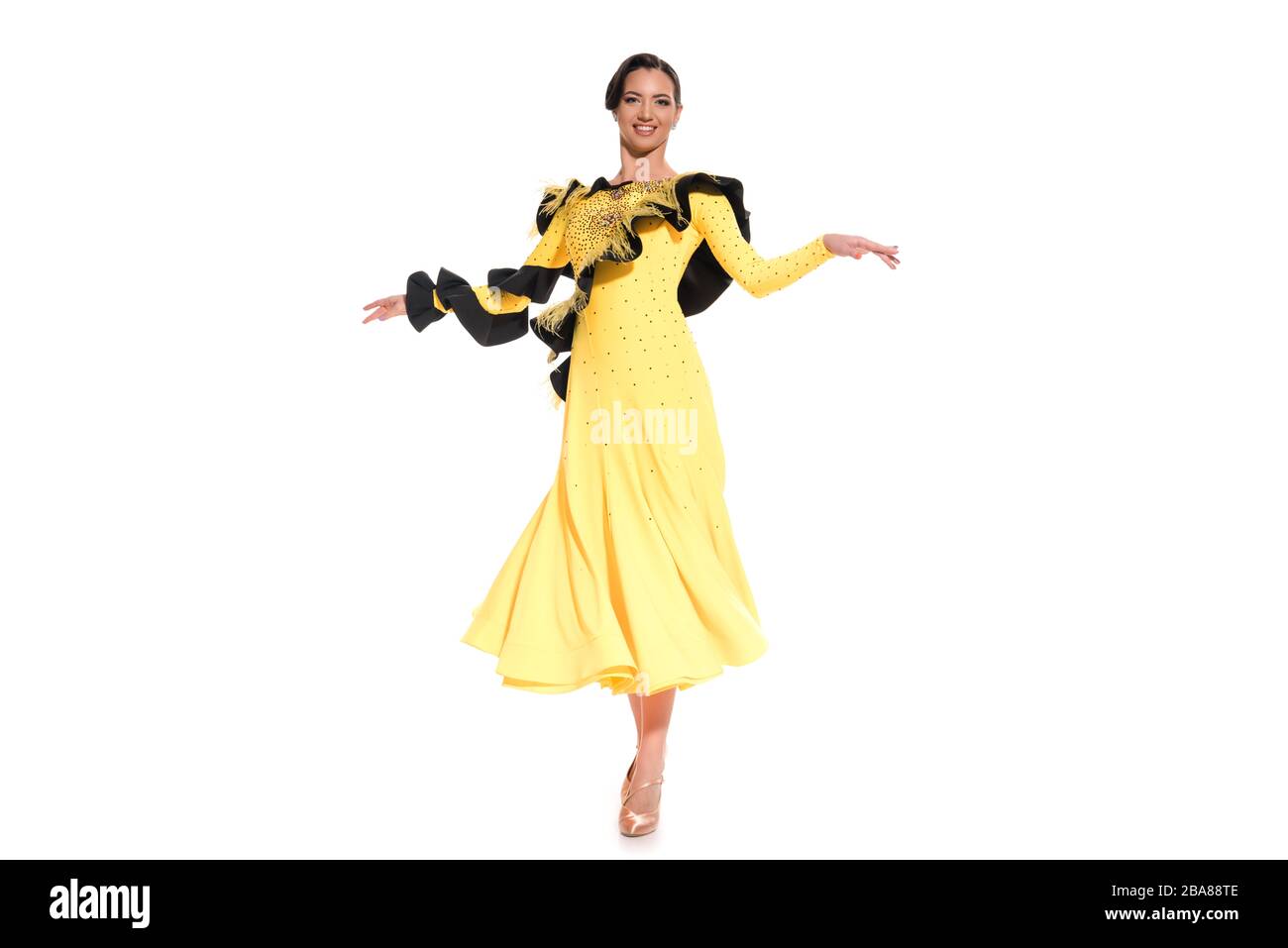 smiling elegant young ballroom dancer in yellow dress dancing isolated ...