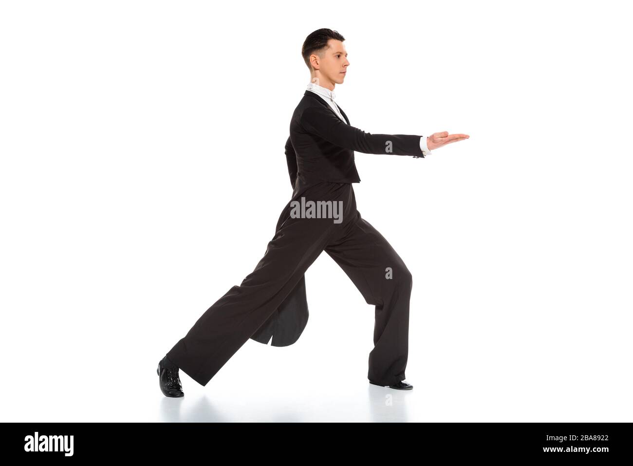 side view of elegant young ballroom dancer dancing on white Stock Photo ...