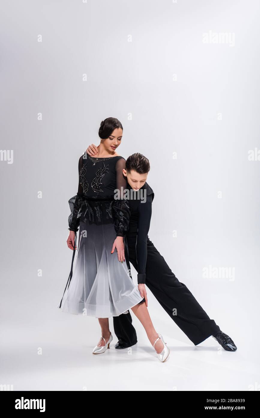elegant young couple of ballroom dancers in black outfit dancing on ...