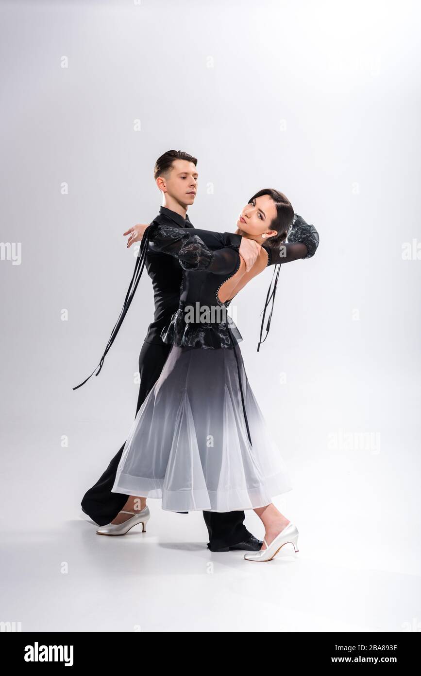 elegant young couple of ballroom dancers in black outfit dancing on ...