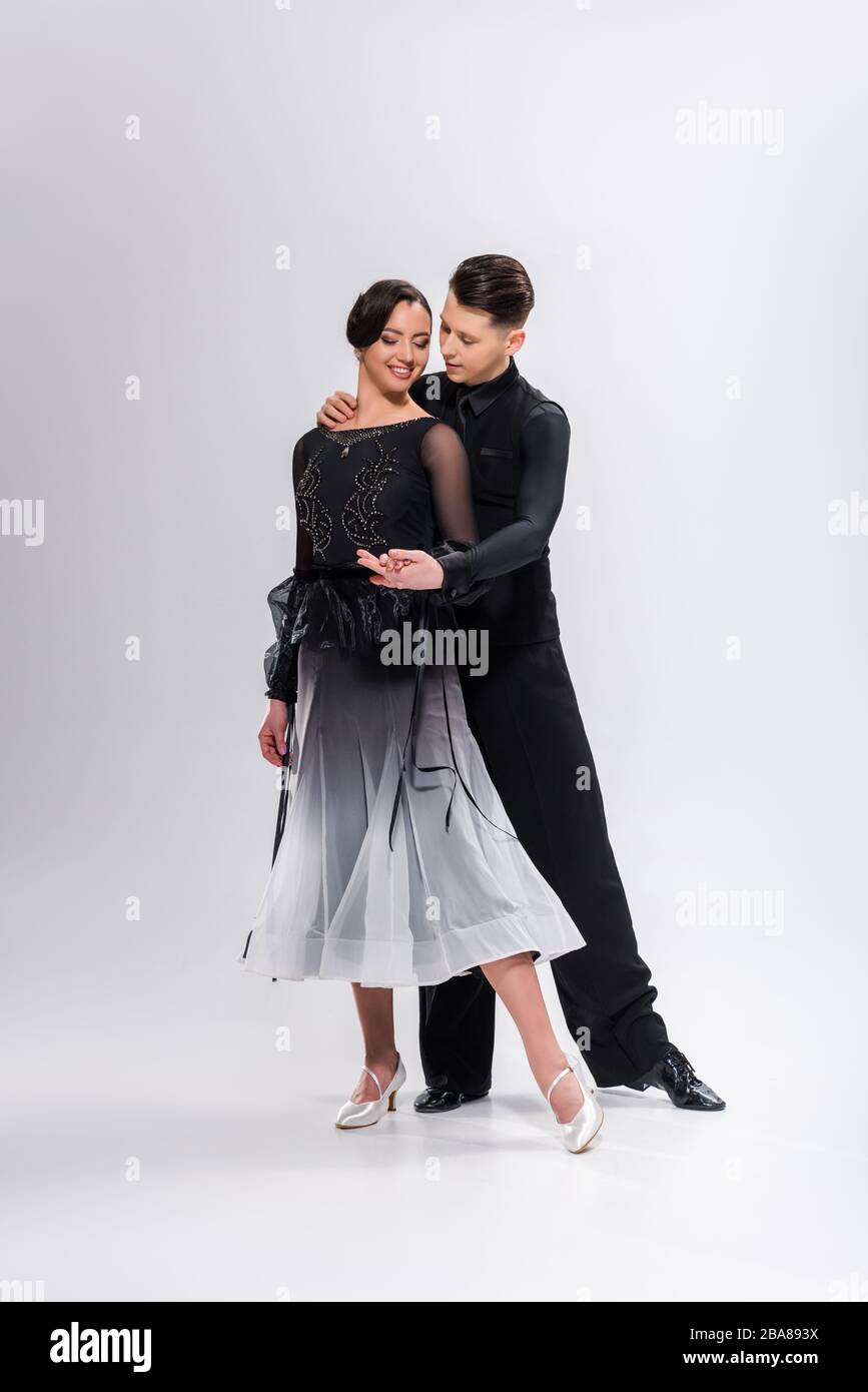 elegant young couple of ballroom dancers in black outfit dancing on ...