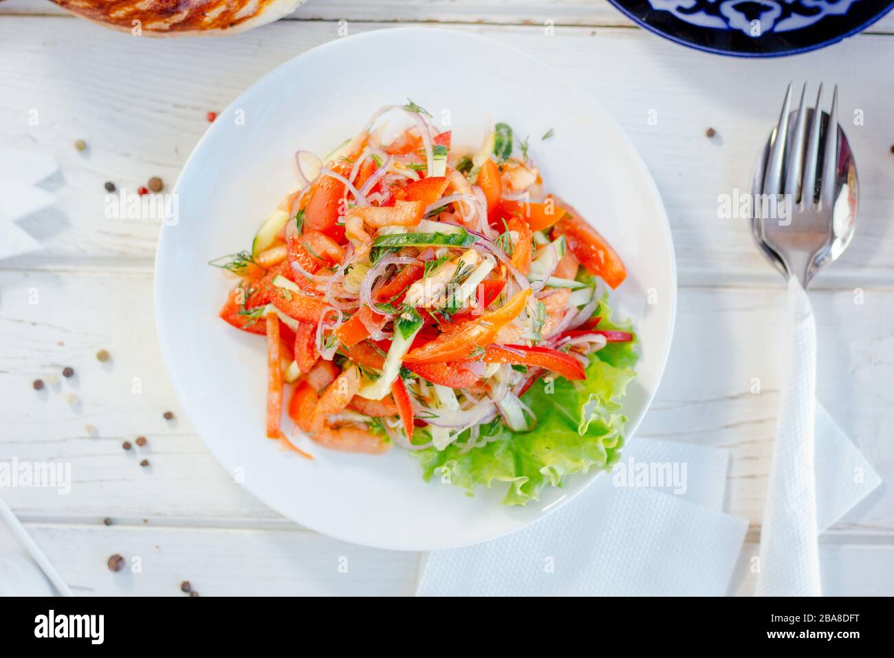 Achik-chukchuk salad with tomatoes and onion at white plate, top view ...
