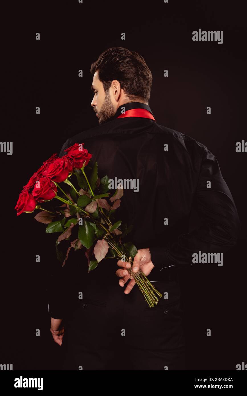 Back view of man in formal wear holding bouquet of roses isolated on ...