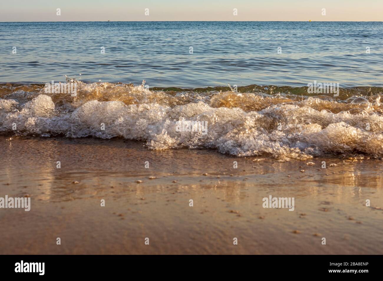 Rolling foaming surf coming onto the beach shoreline Stock Photo - Alamy