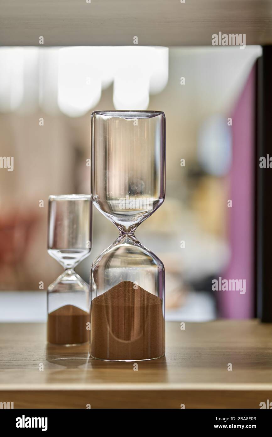 Closeup view at hourglasses with brown sand Stock Photo - Alamy