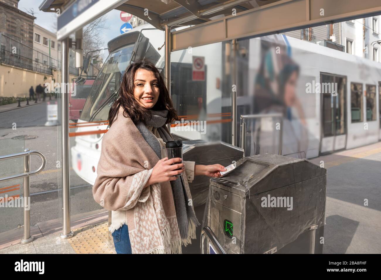 Beautiful young girl uses metrocard to pay the commuter fare and enter ...