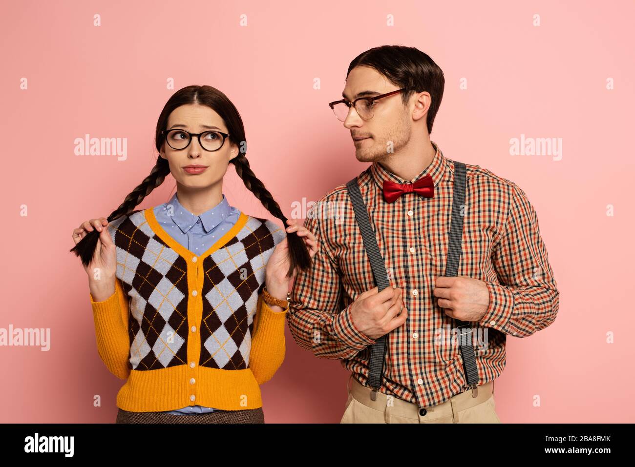 couple of confused nerds in eyeglasses on pink Stock Photo - Alamy