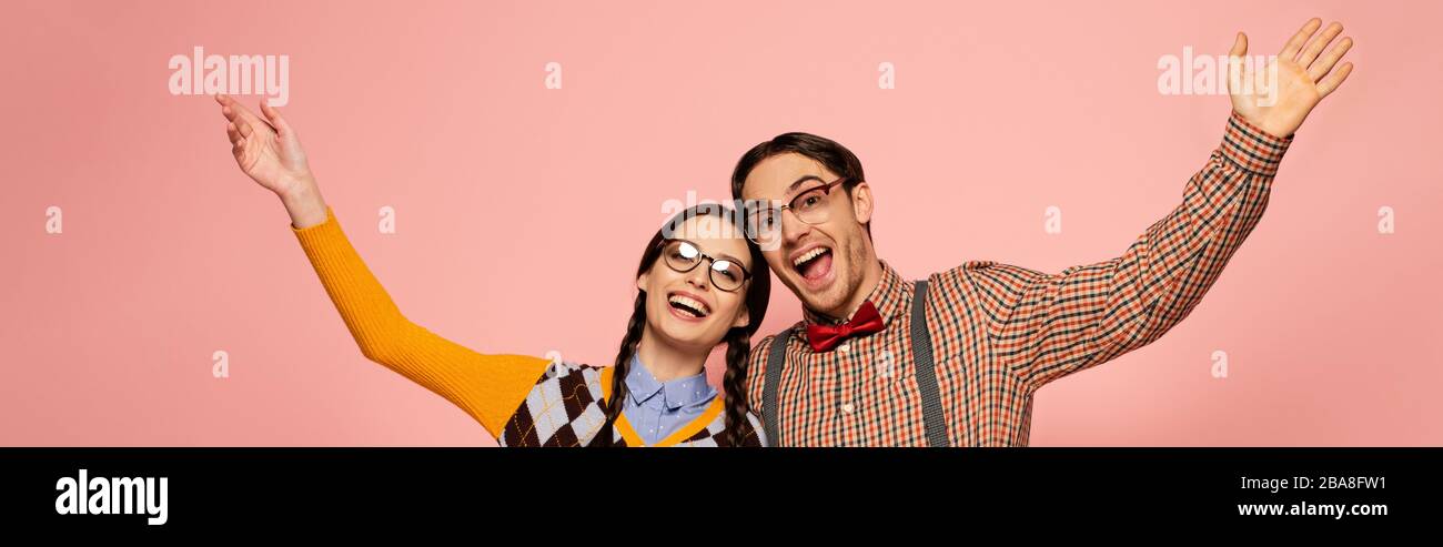 panoramic shot of couple of happy nerds in eyeglasses gesturing and ...