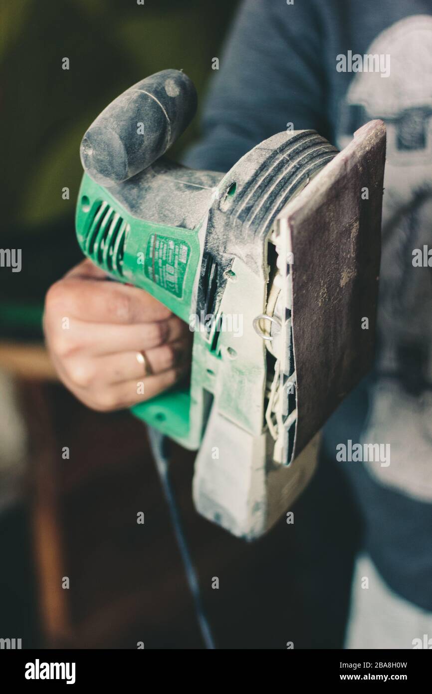 Electric sandpaper tool in a hand of carpenter. Great photo for your ...