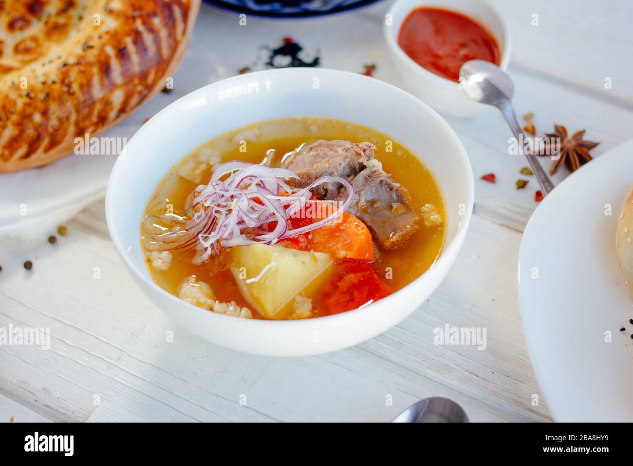 Uzbek chorba - soup from fresh meat and vegetables on white table ...