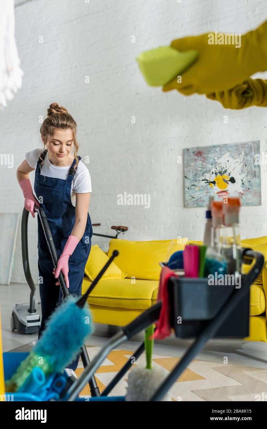 selective focus of attractive cleaner using vacuum cleaner near ...