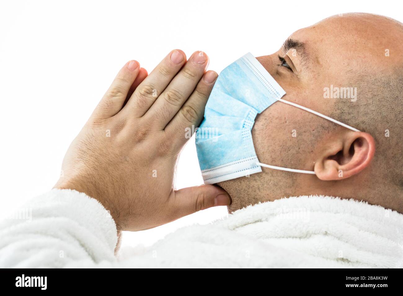 Caucasian sick young man with medical protective face mask praying to ...