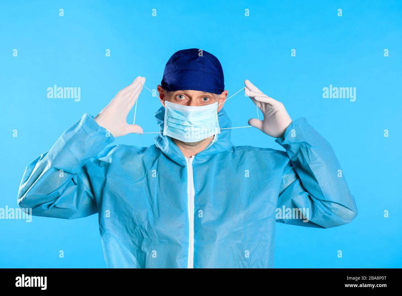 Man in a white decontamination suit putting on medical gloves Stock ...