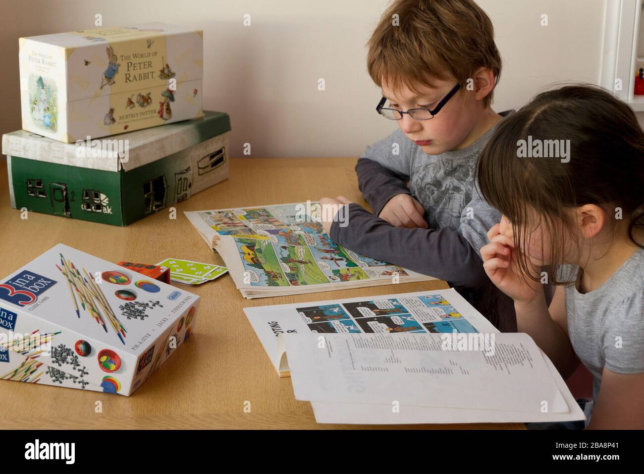 Boy and girl reading comic books together Stock Photo - Alamy