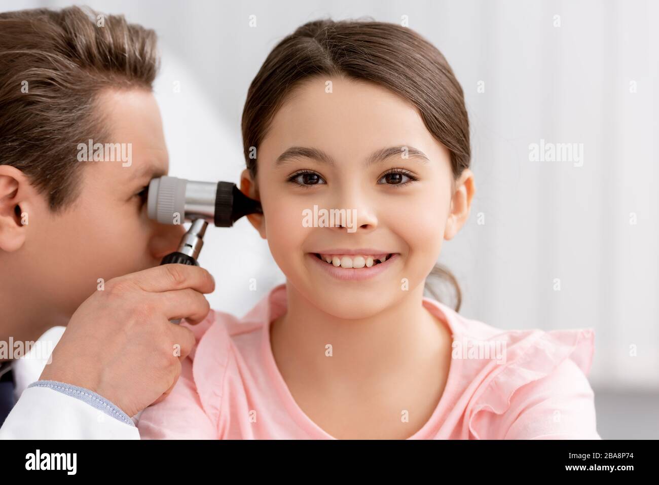 ent physician examining ear of cheerful kid with otoscope Stock Photo ...
