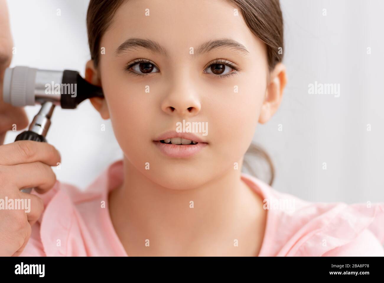 cropped view of ent physician examining ear of adorable kid with ...