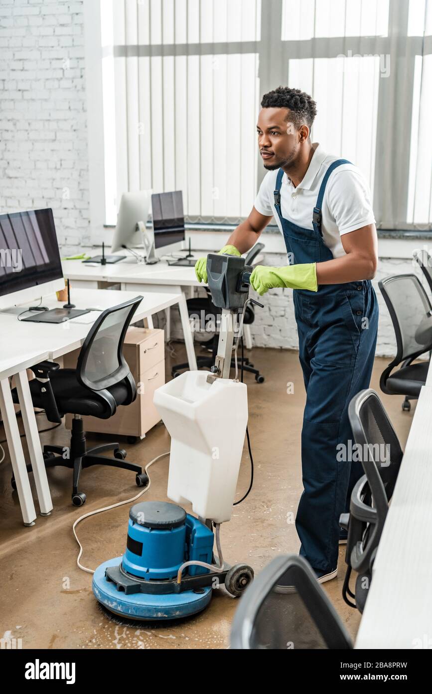handsome african american cleaner washing floor in office with cleaning ...