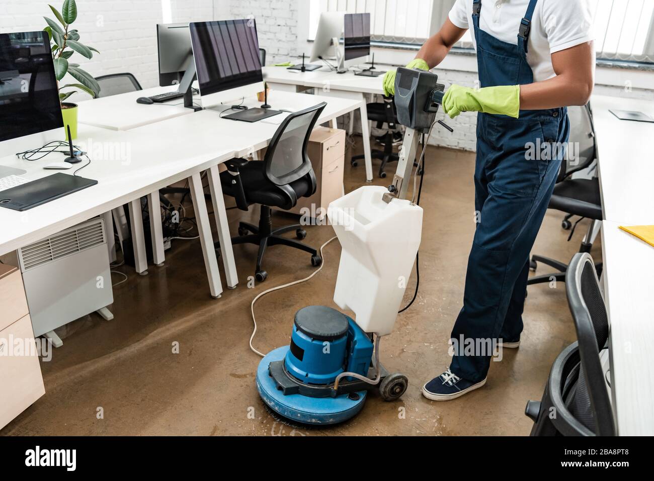 partial view of african amercan cleaner washing floor with cleaning ...