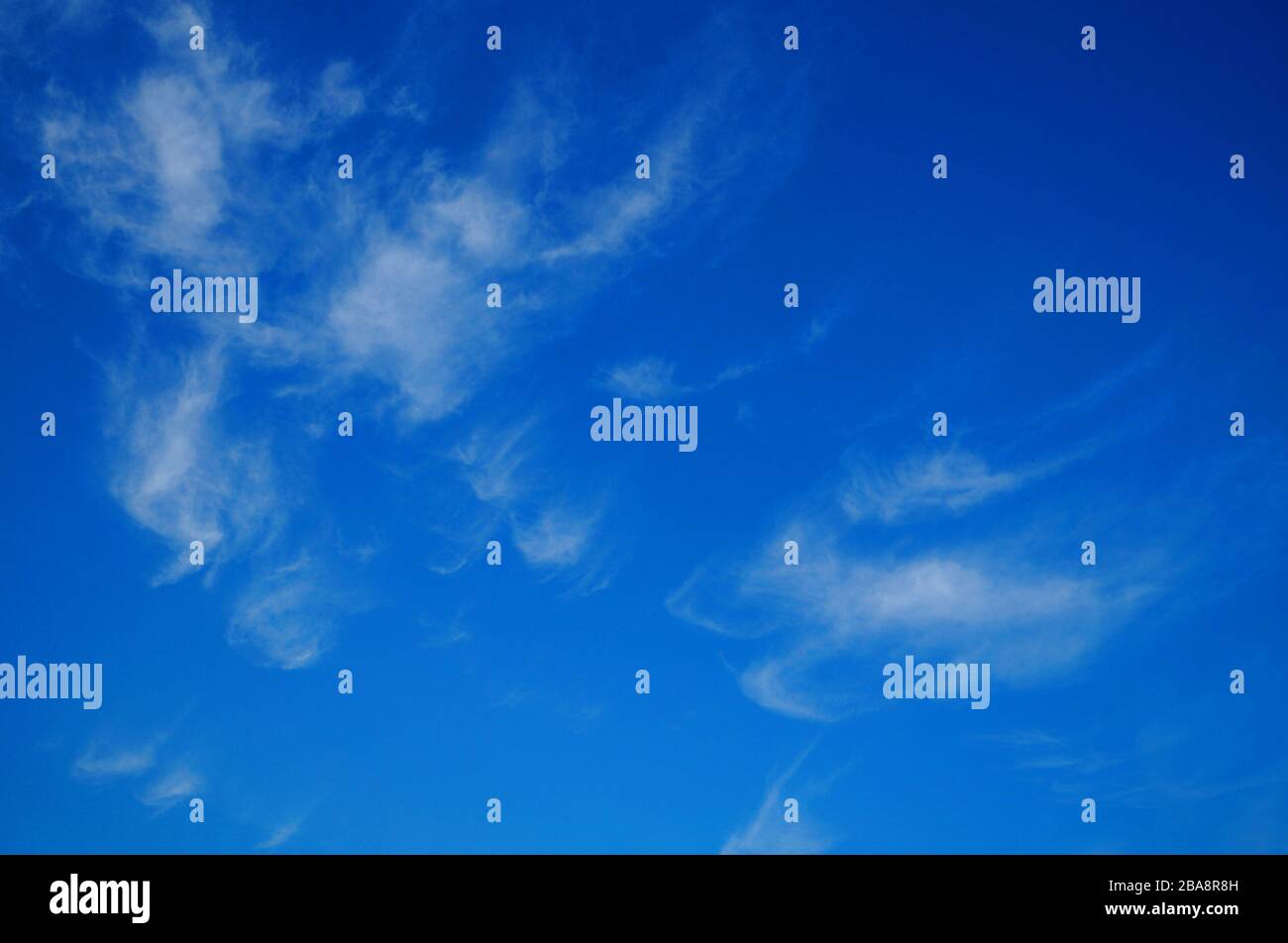 White fluffy soft clouds on a blue saturated sky on a sunny summer day ...