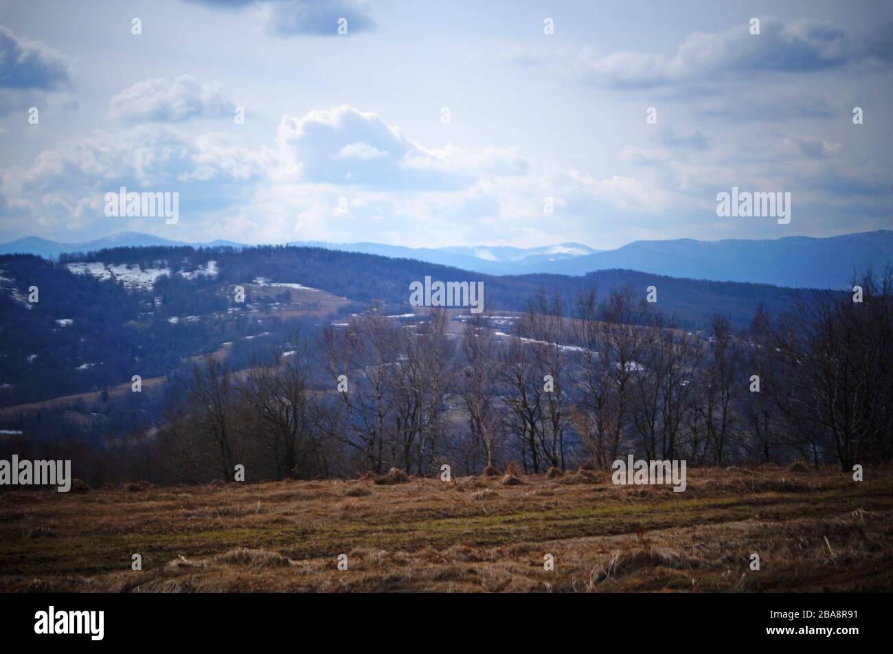 View of autumn mountains with trees without leaves under a cold gray ...