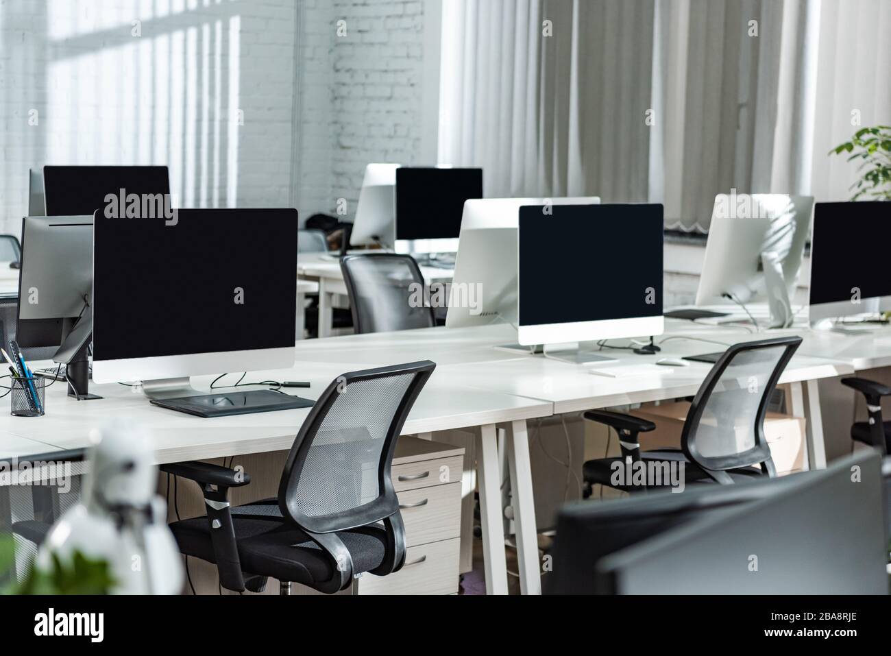 modern open space office with computer monitors on white desks Stock ...
