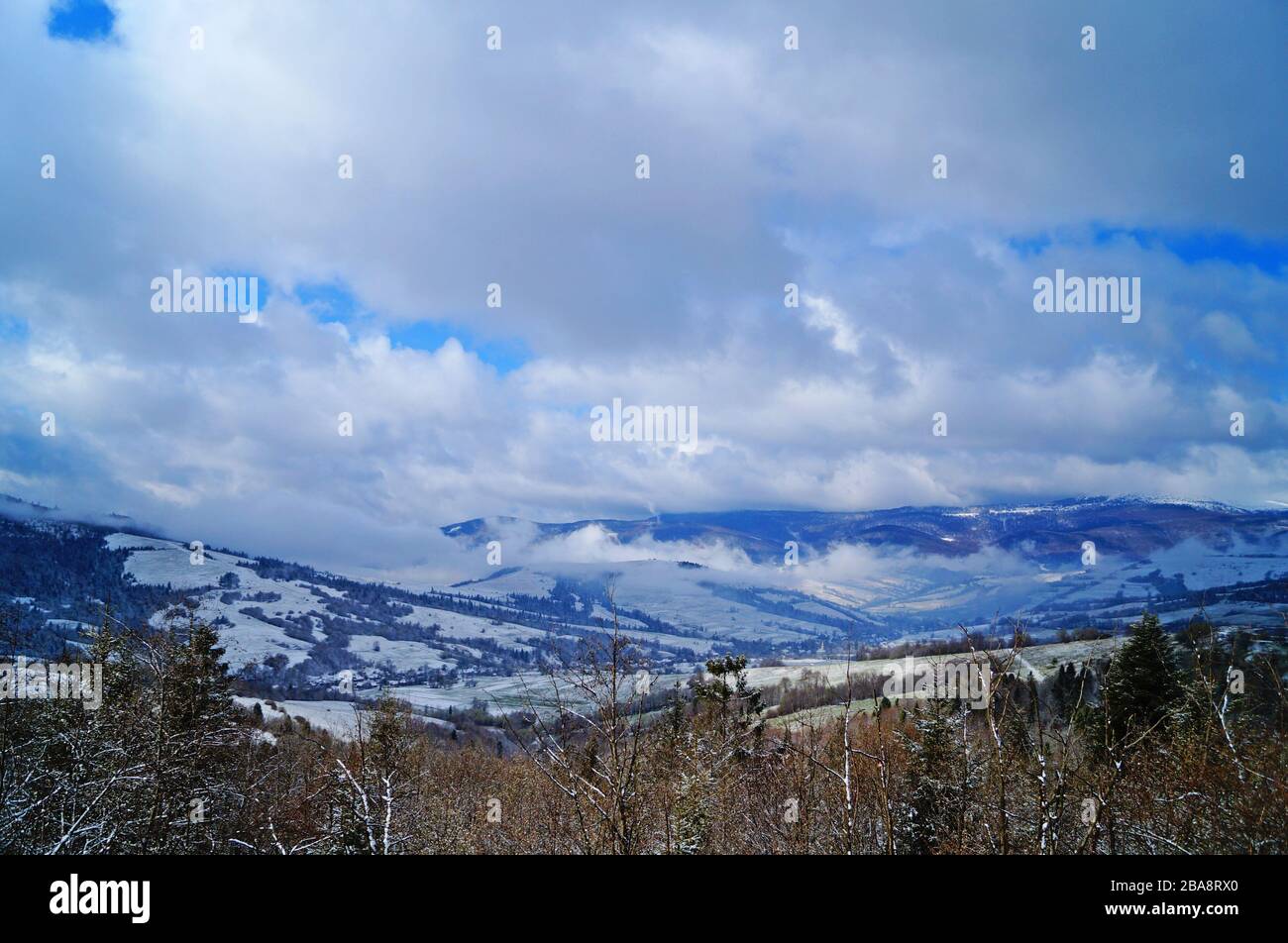 Mountain view covered with snow under a blue sky with white clouds on a ...