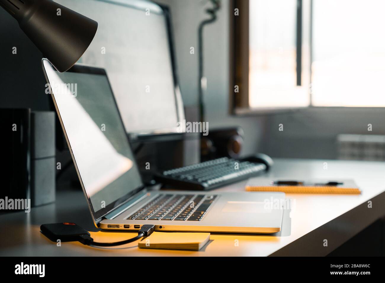Work desk with a lighted lamp and computers, working from home Stock ...