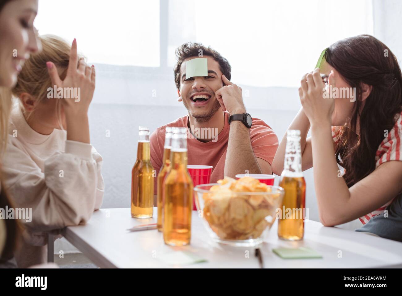 cheerful man with sticky note on forehead playing name game with ...