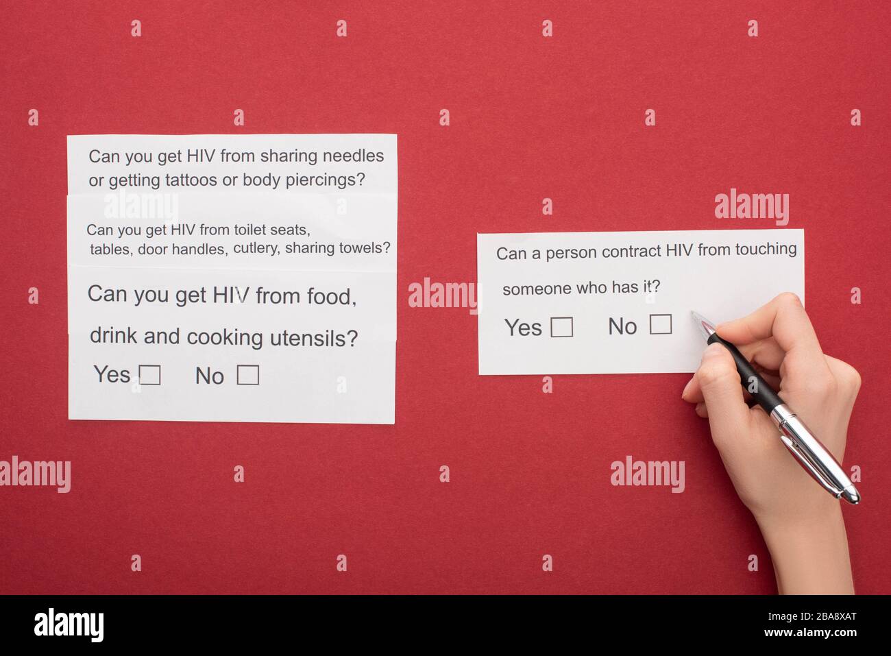 partial view of woman answering HIV questionnaire on red background ...