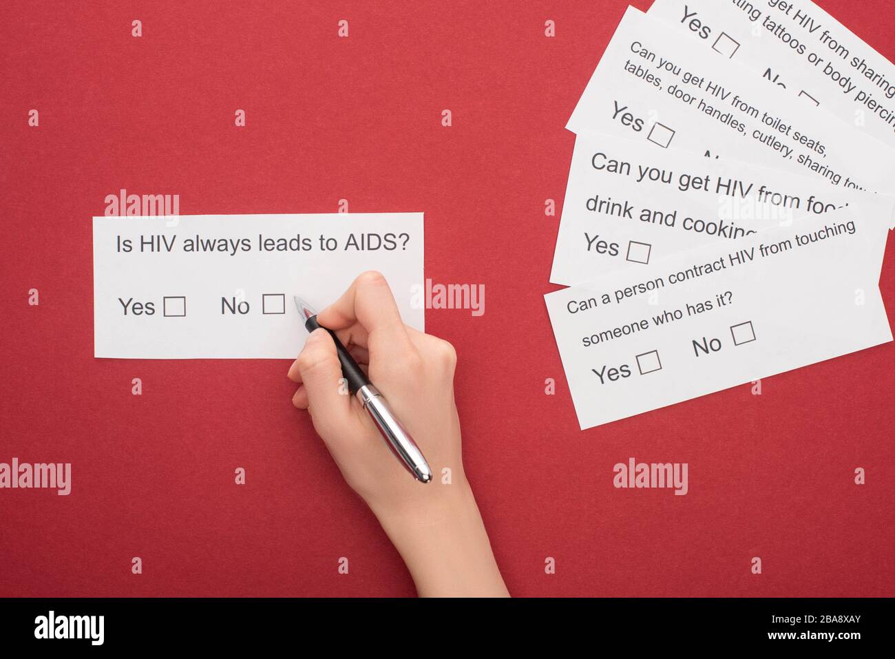 partial view of woman answering HIV questionnaire on red background ...