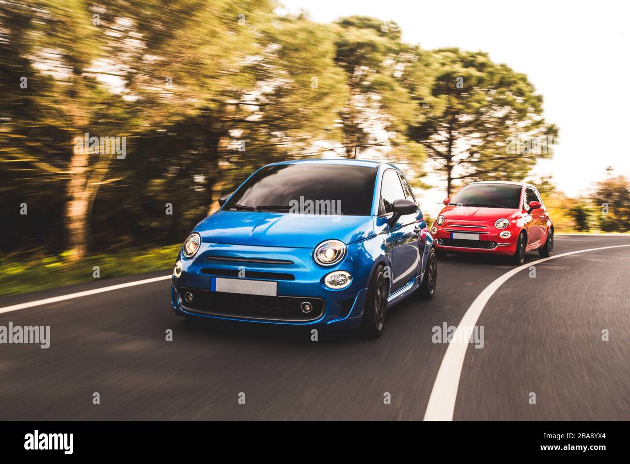 Blue and red mini cars on the forest road Stock Photo - Alamy