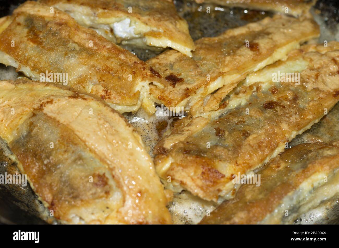 Tidbits of cod fish Whiting in batter are laid out in rows close up ...
