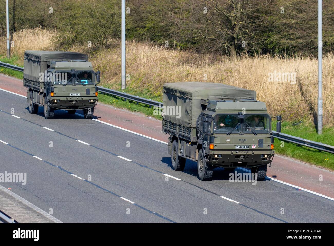 Canvas-covered MAN HX60 18.330 4x4 Army lorries in convoy on the M6 ...