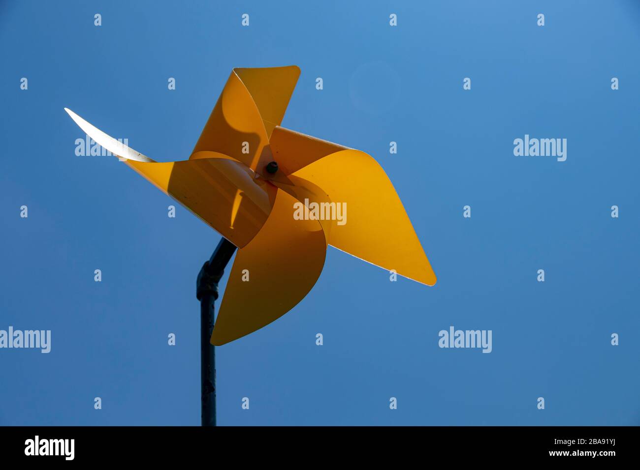 a yellow windmill that stands against the blue sky Stock Photo - Alamy