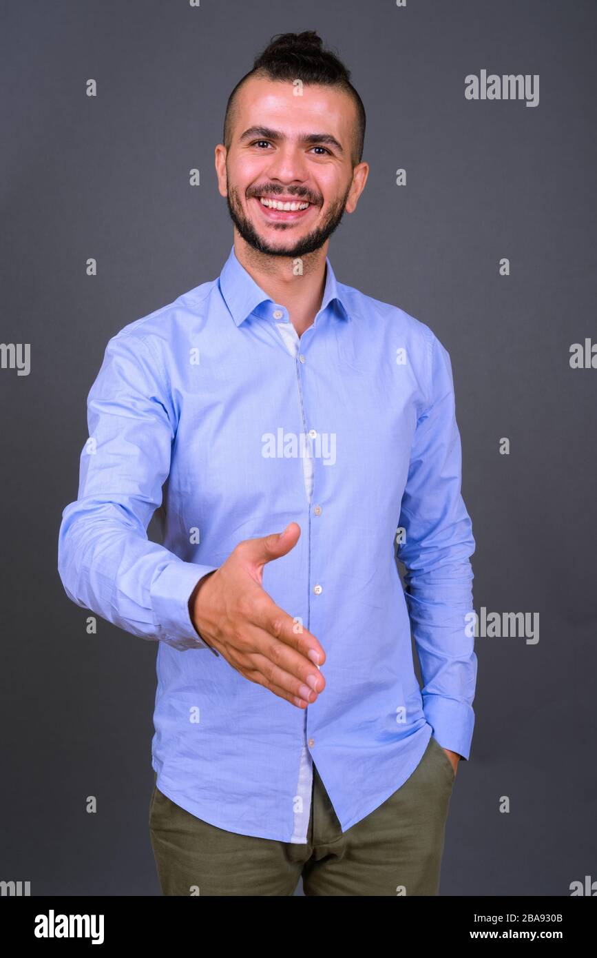 Portrait of happy bearded Turkish businessman giving handshake Stock ...