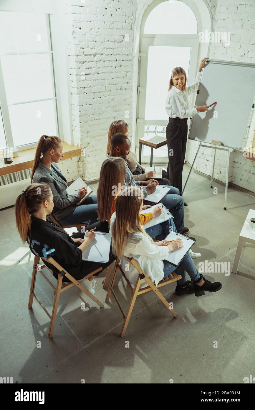 Advanced. Female speaker giving presentation in hall at workshop ...